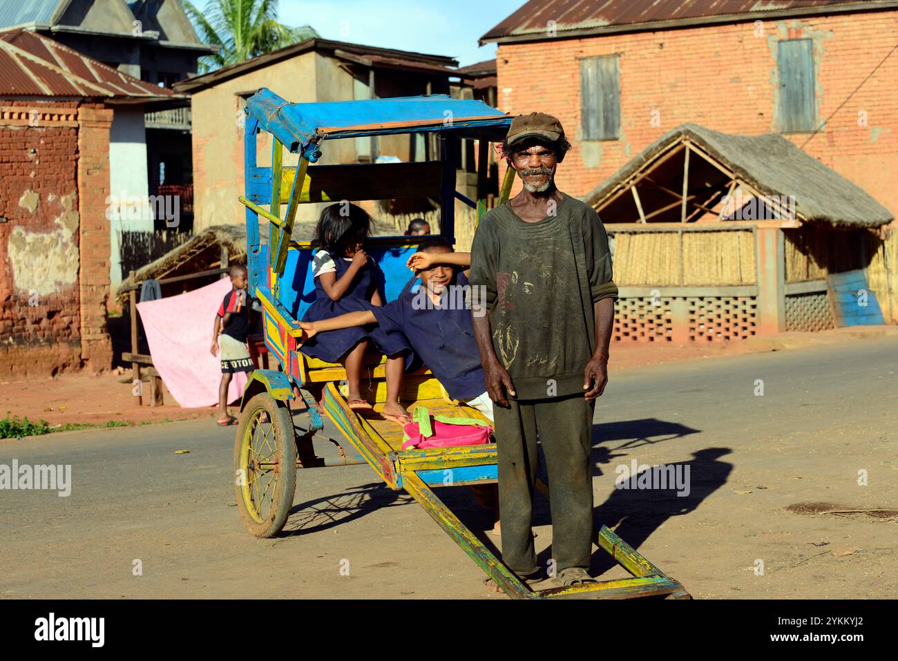A joyful pousse-pousse driver in a small town in the central highlands ...