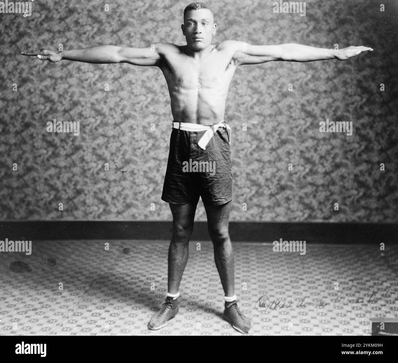Boxer Tut Jackson clothed in boxing trunks, full-length portrait ...