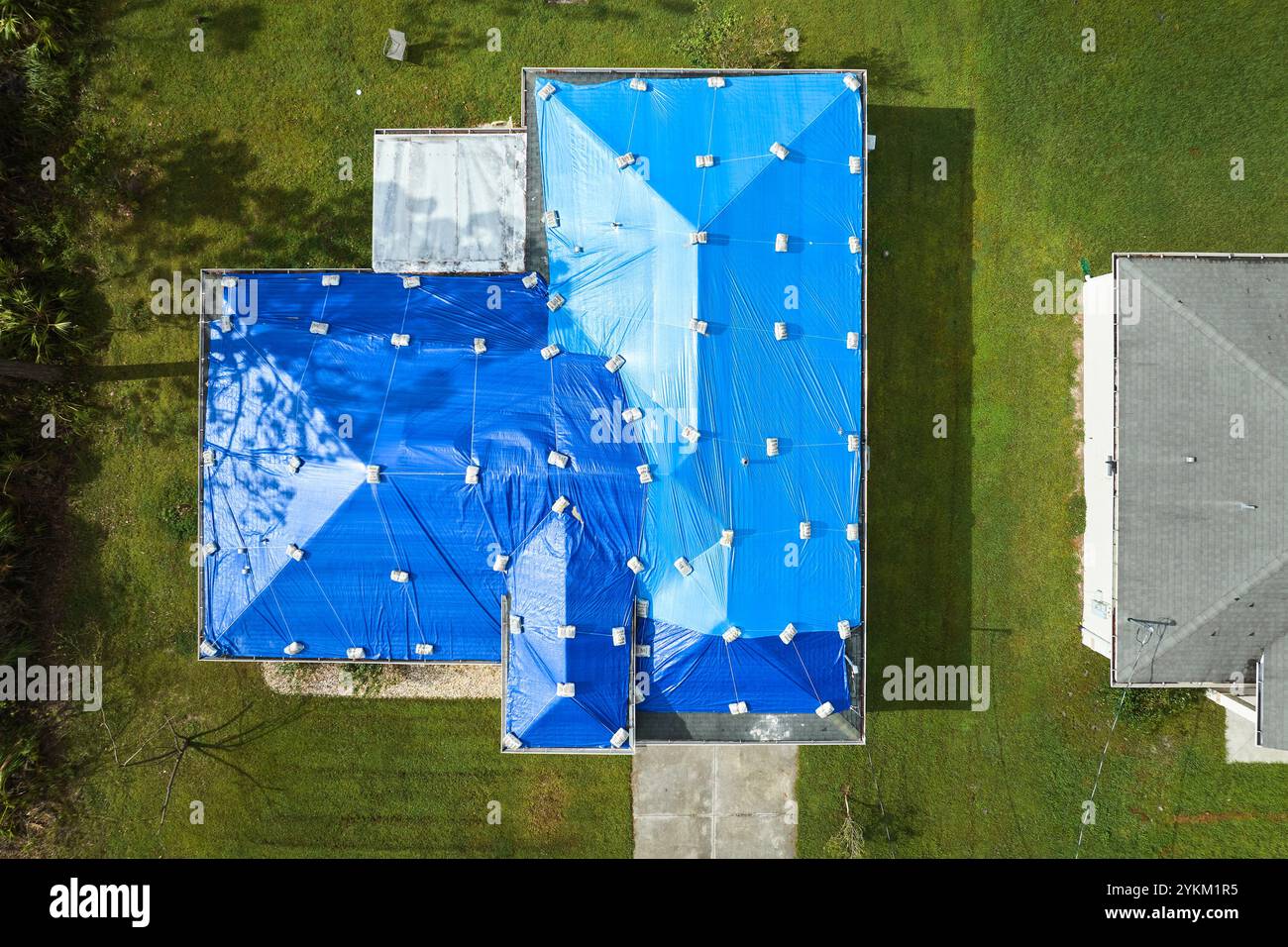 Top view of leaking house roof covered with protective tarp sheets ...