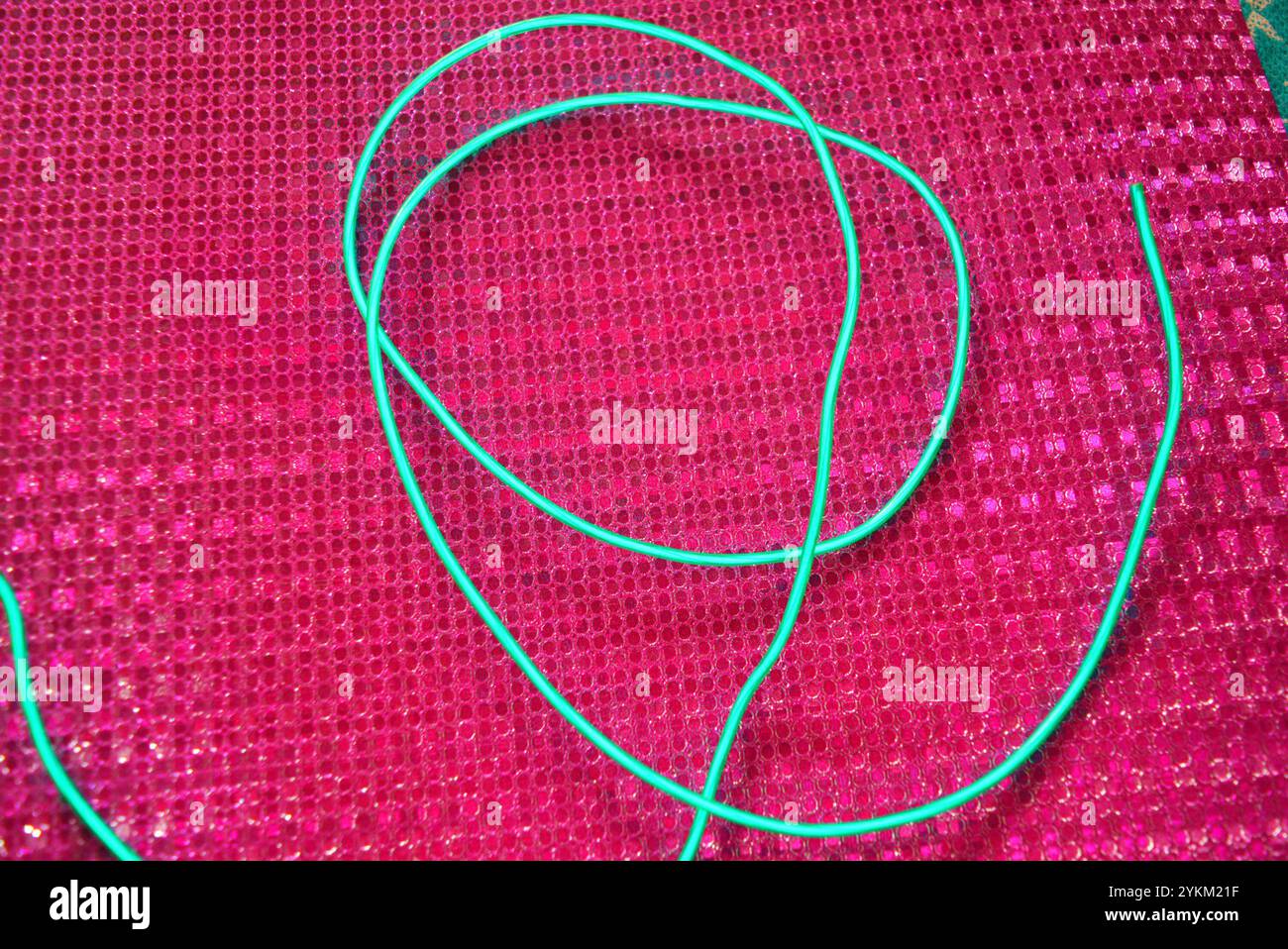 An unusual glowing, electroluminescent green el wire is located on a ...