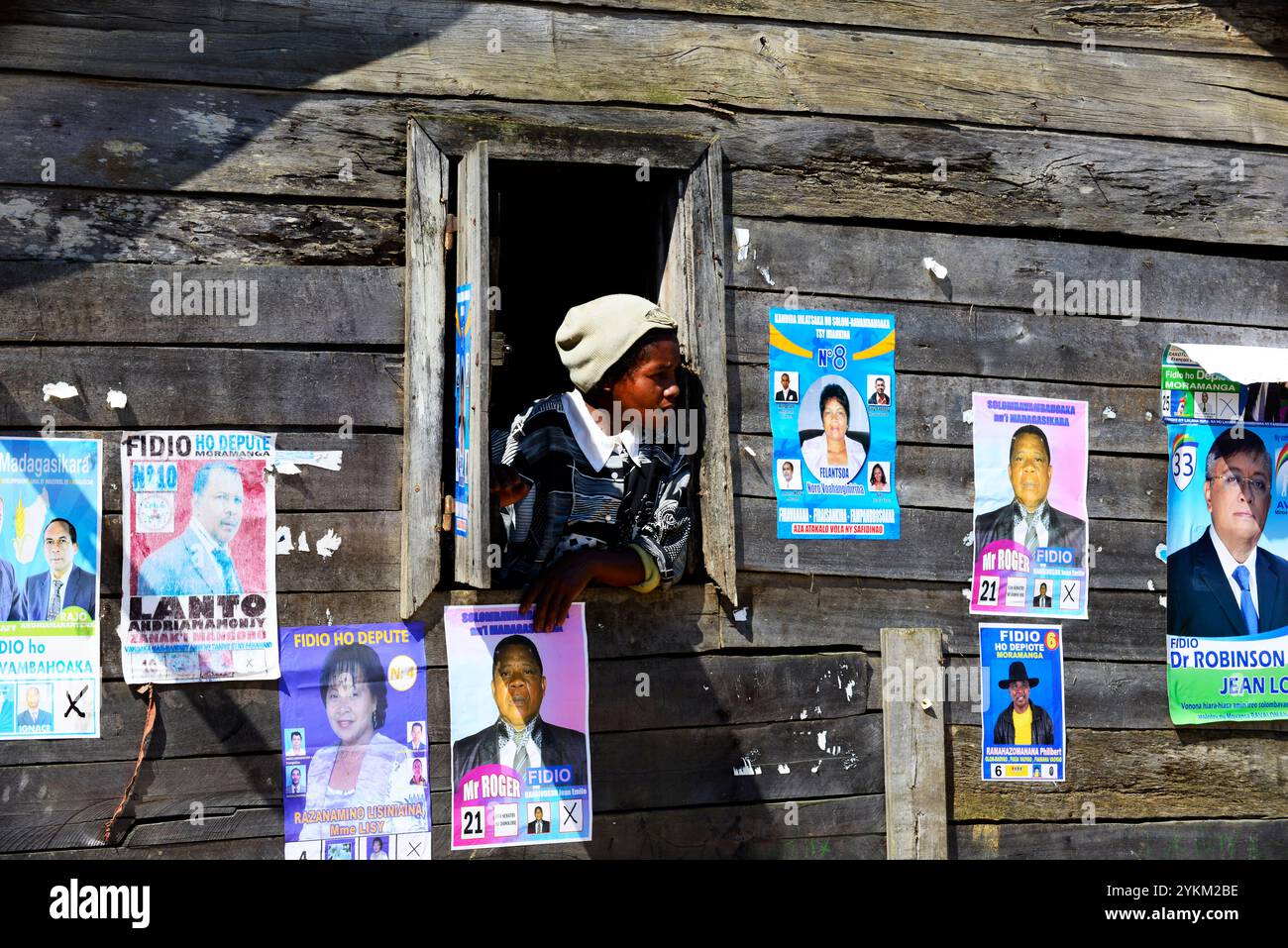 A Malagasy woman looking out the window of her home in Andasibe ...