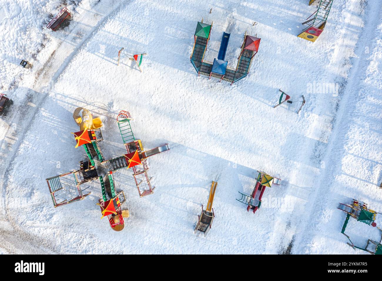 snow-covered colorful playground in winter park after snowfall. aerial ...