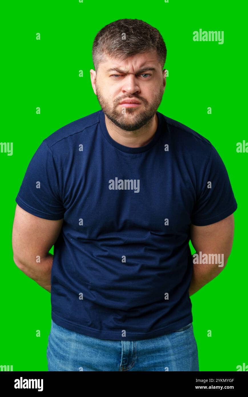 Man expressing confusion with crossed arms in front of a bright green ...