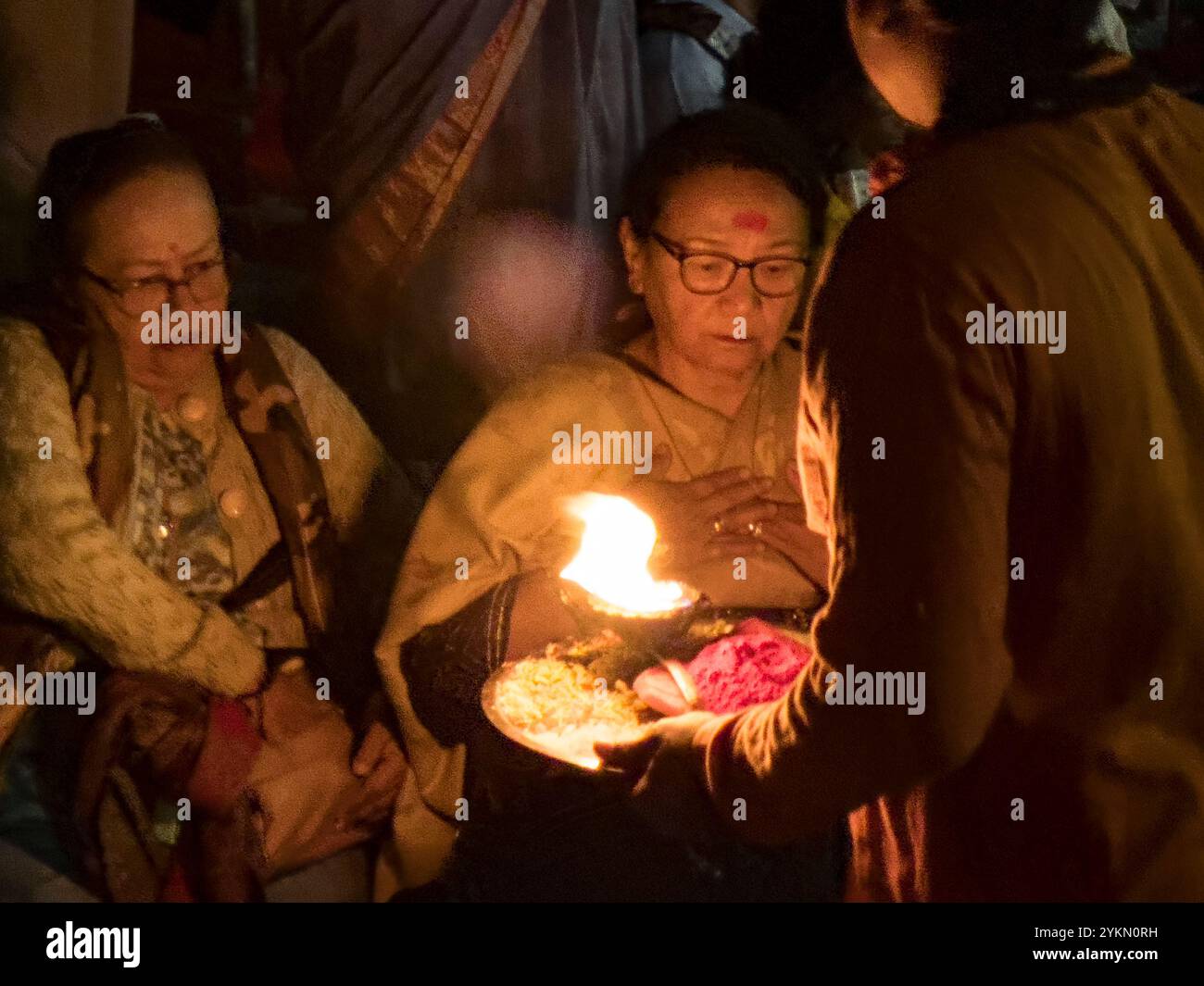 Women participate in a flame offering during a cultural aarti ritual in ...