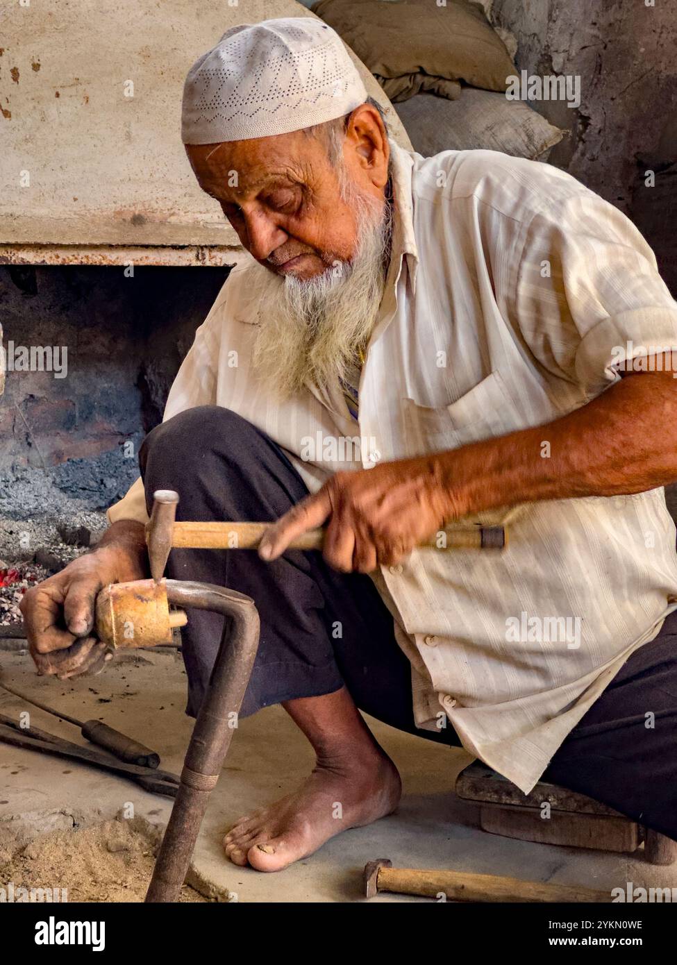 Experienced elderly craftsman dedicated to traditional manual labor ...