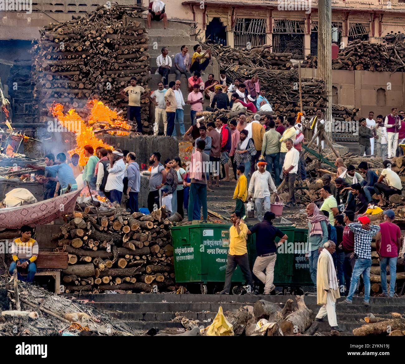 Crowd gathers around a blazing funeral pyre during a traditional indian ...