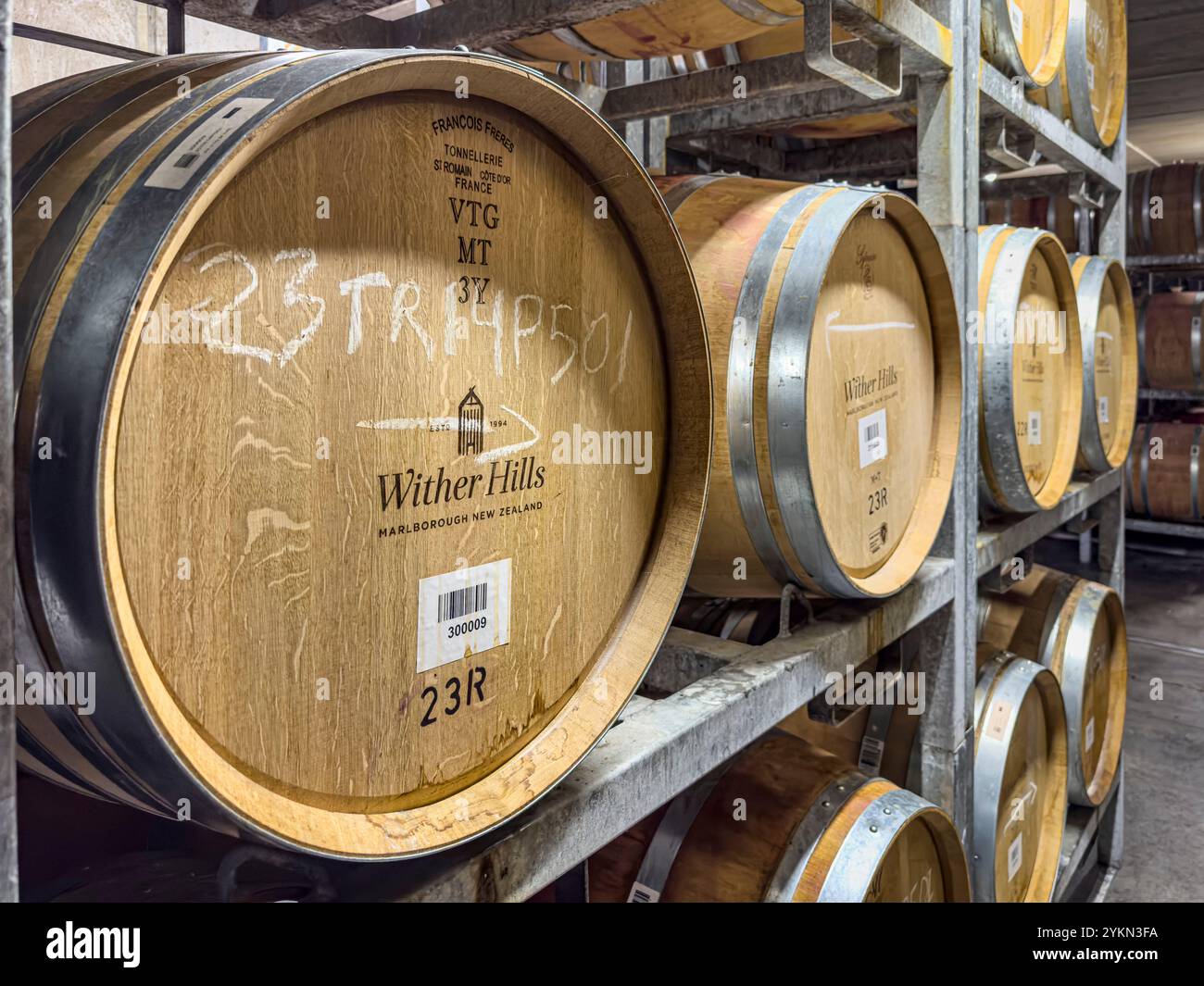Stacked oak wine barrels aging in a dimly lit winery cellar Stock Photo ...