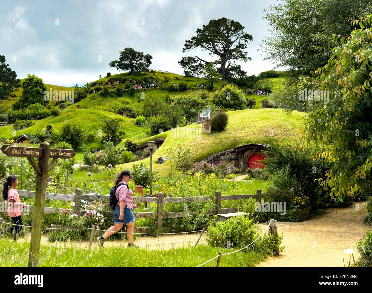 Visitors wander the picturesque hobbiton, featuring iconic hobbit holes ...