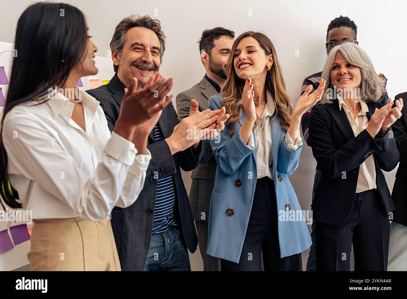 Enthusiastic diverse business team applauding and celebrating success in modern office ...