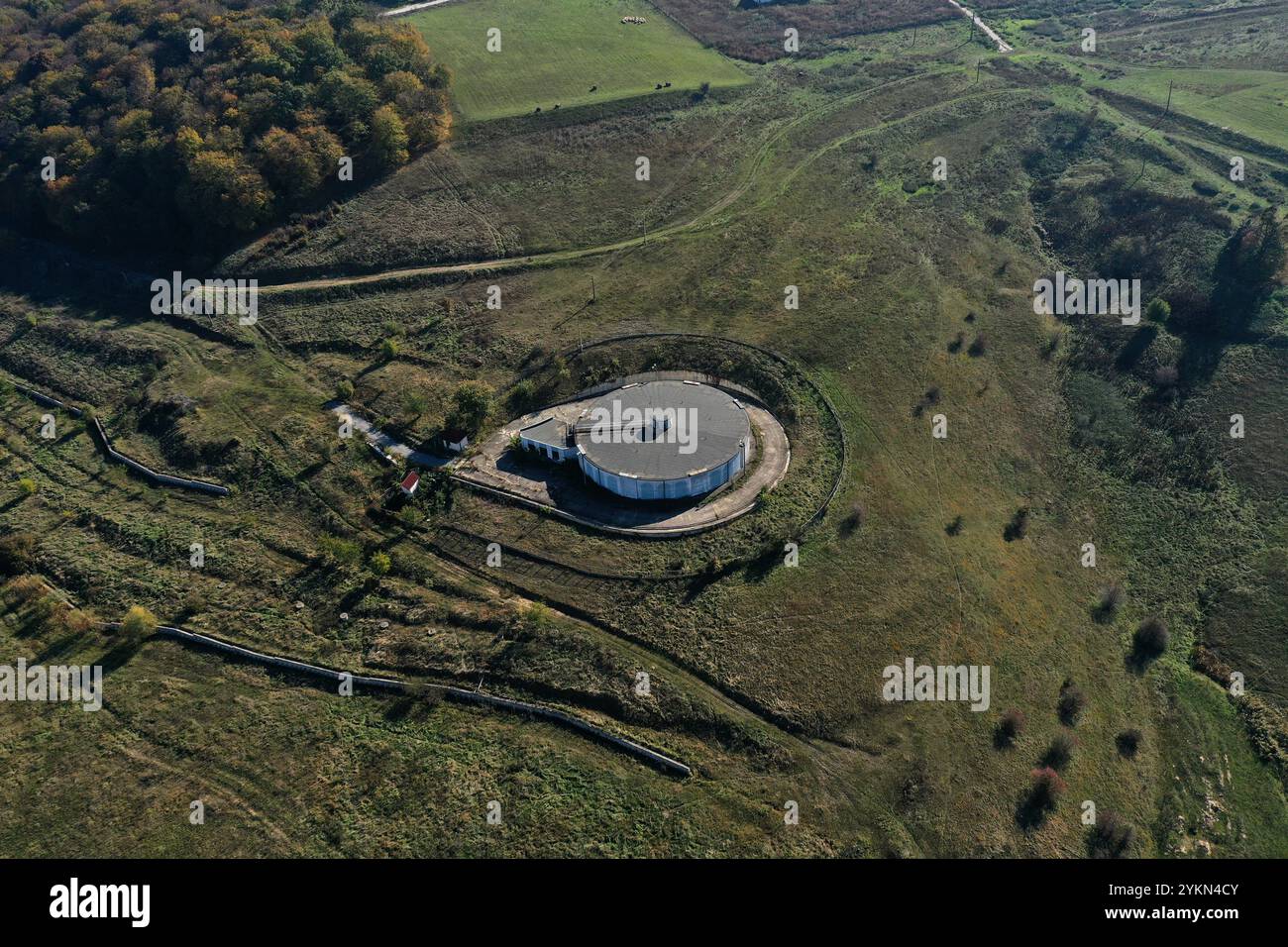 Aerial view of big concrete water tank reservoir in the meadow by drone ...