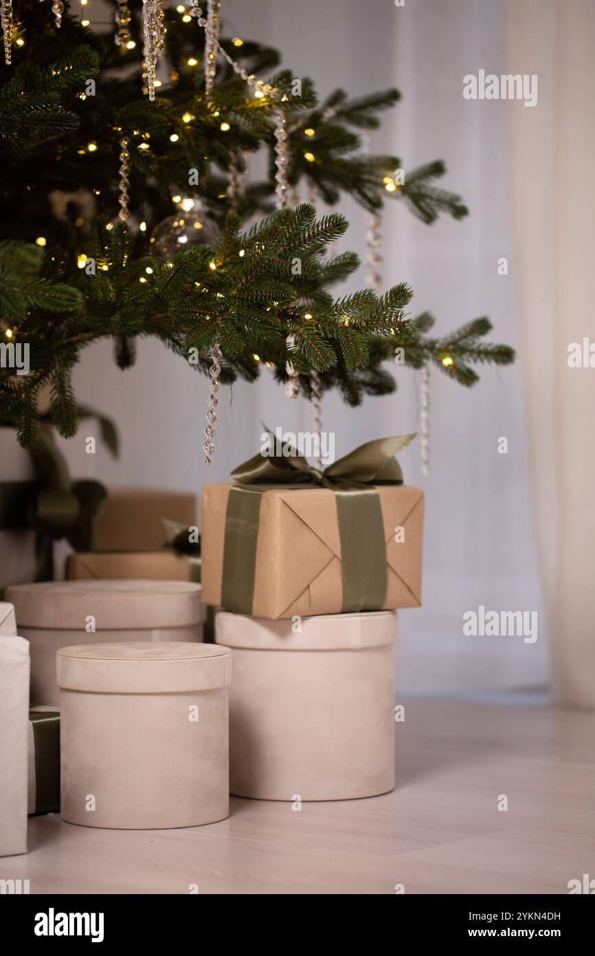 Many gift boxes with ribbons piled up under the Christmas tree, close ...