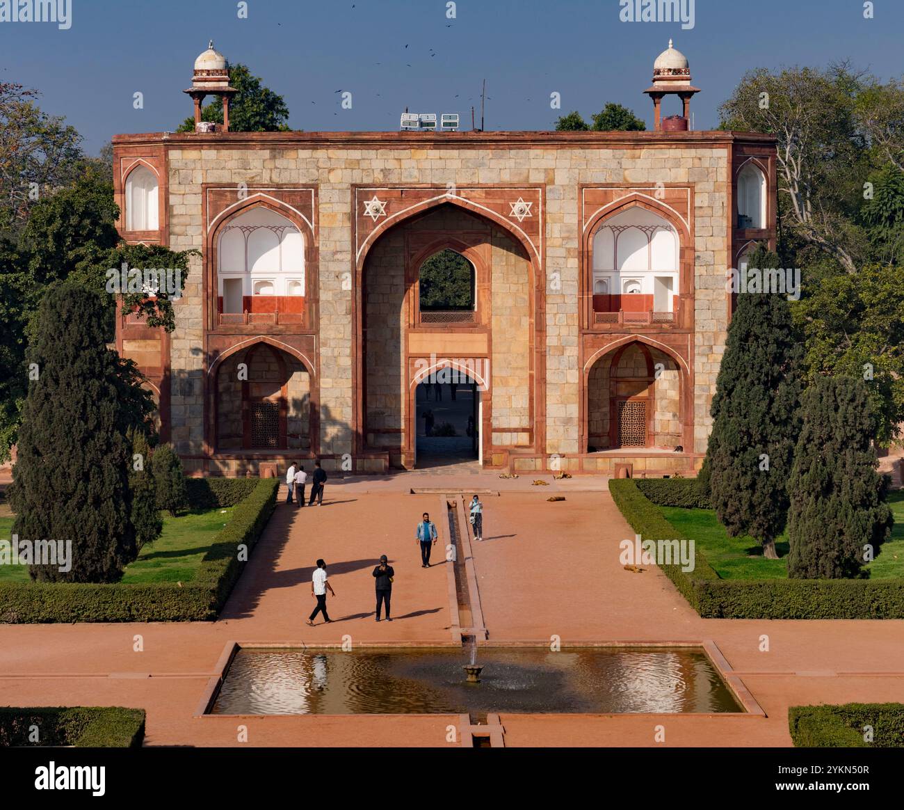 Tourists explore an ancient mughal monument with arches and domes at ...