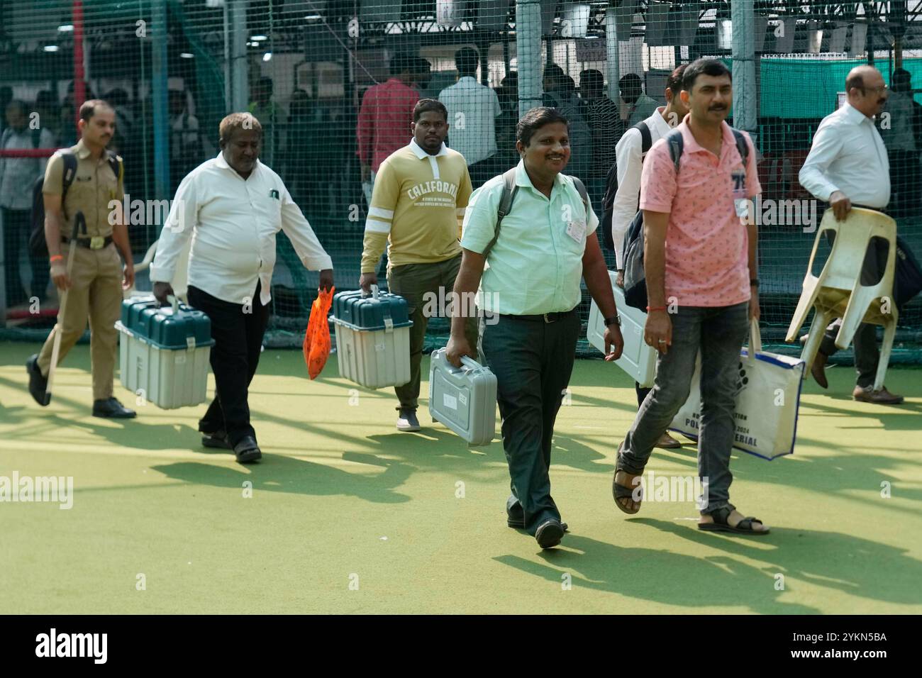 Indian election officials walk carrying polling material on the eve of ...