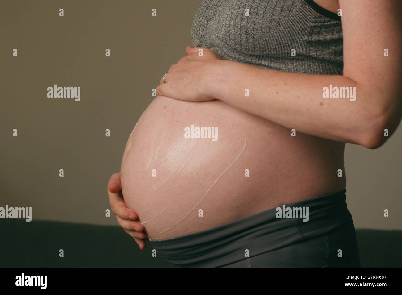 Expectant Mother Tenderly Holding Pregnant Belly in a Relaxed Setting ...