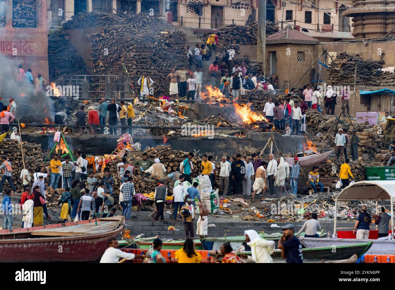 Traditional funeral pyres burn brightly as people gather along the ...