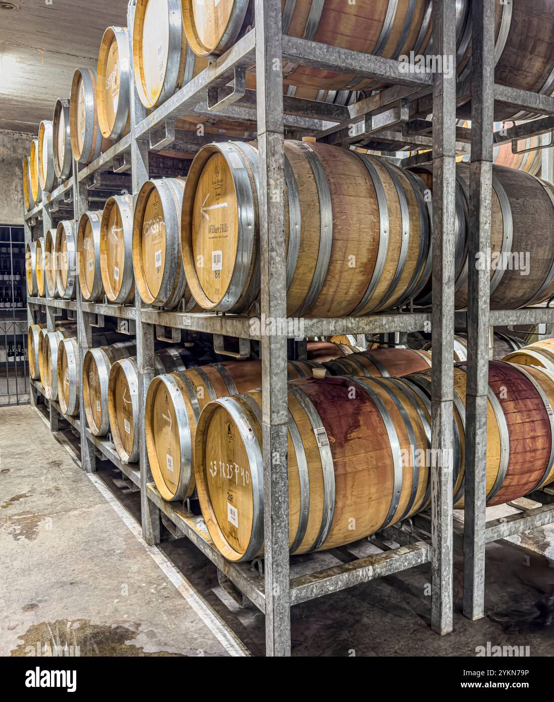 Stacked wooden barrels aging wine in a traditional cellar Stock Photo ...