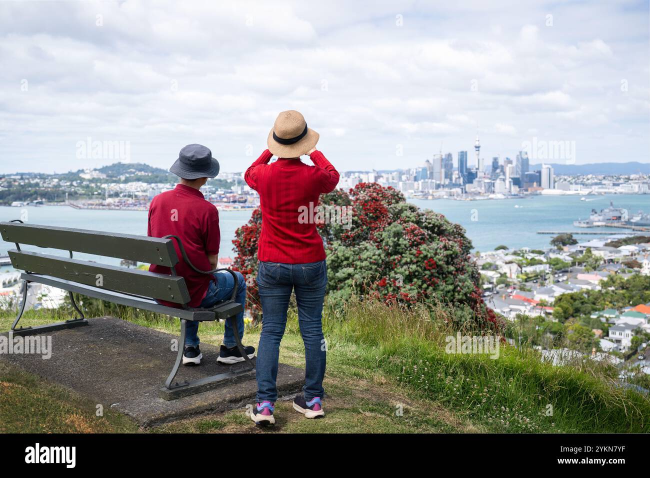 Couple enjoying the views of Auckland Sky Tower and skyline. Pohutukawa ...