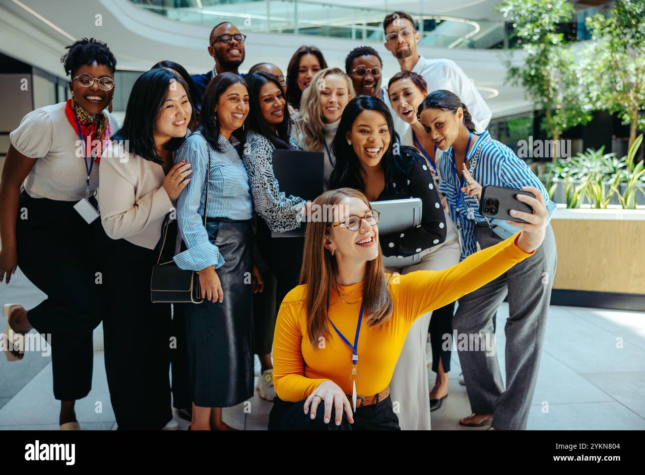 A diverse group of coworkers at an auditing firm take a joyful group ...