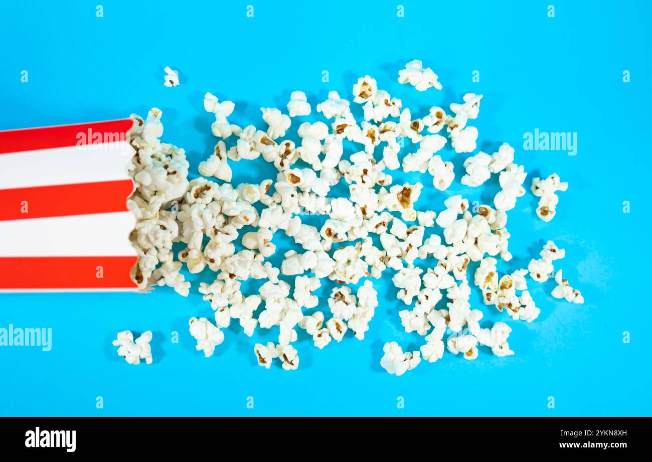 Top view of fallen red and white cardboard bucket scattering popcorn on ...