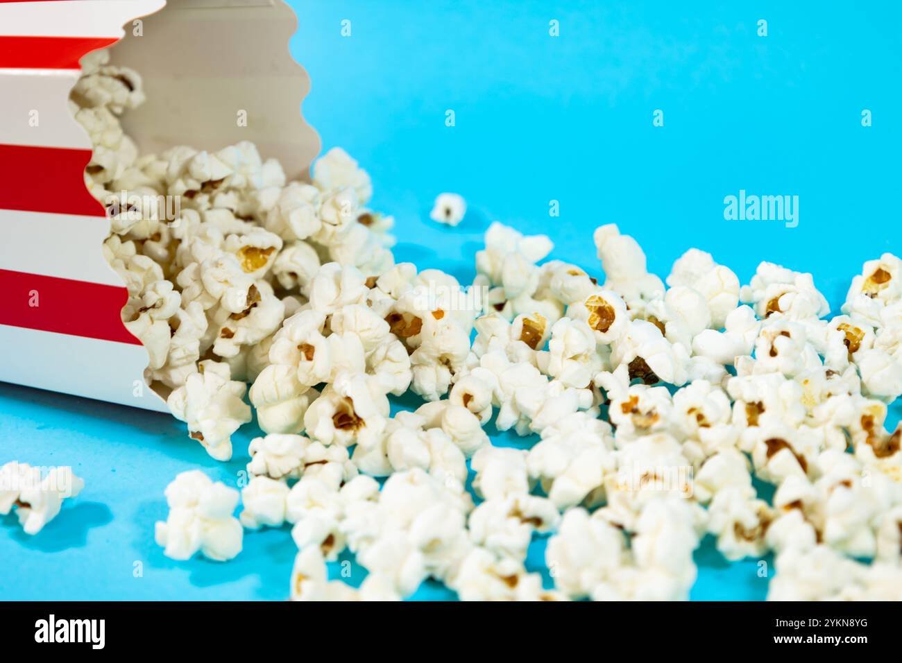 Close up of fallen red and white cardboard bucket scattering popcorn on ...