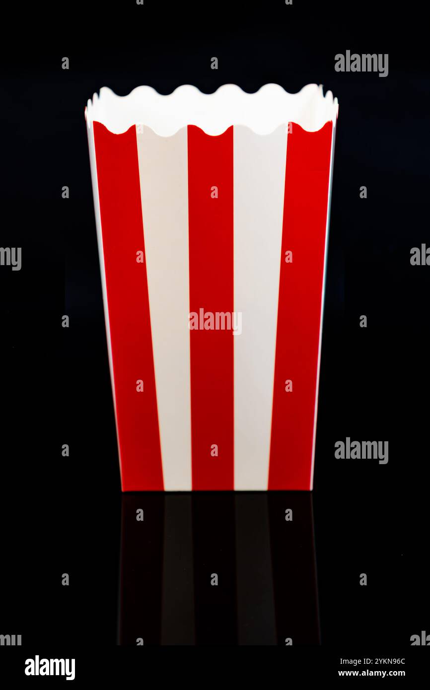 Vertical image of cardboard popcorn bucket reflected on a black ...
