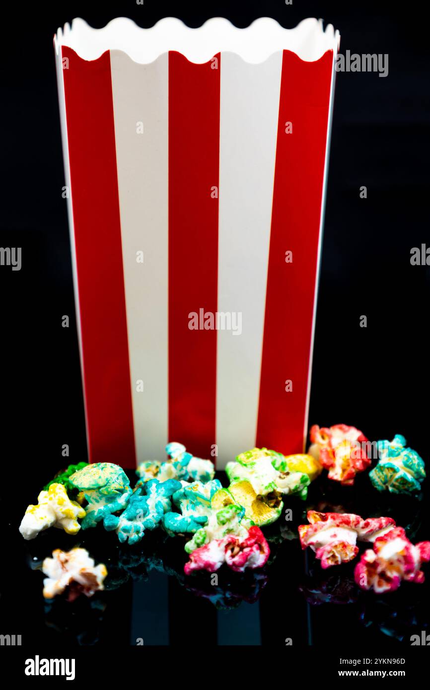 Vertical image of cardboard bucket with colorful popcorn reflected on a ...