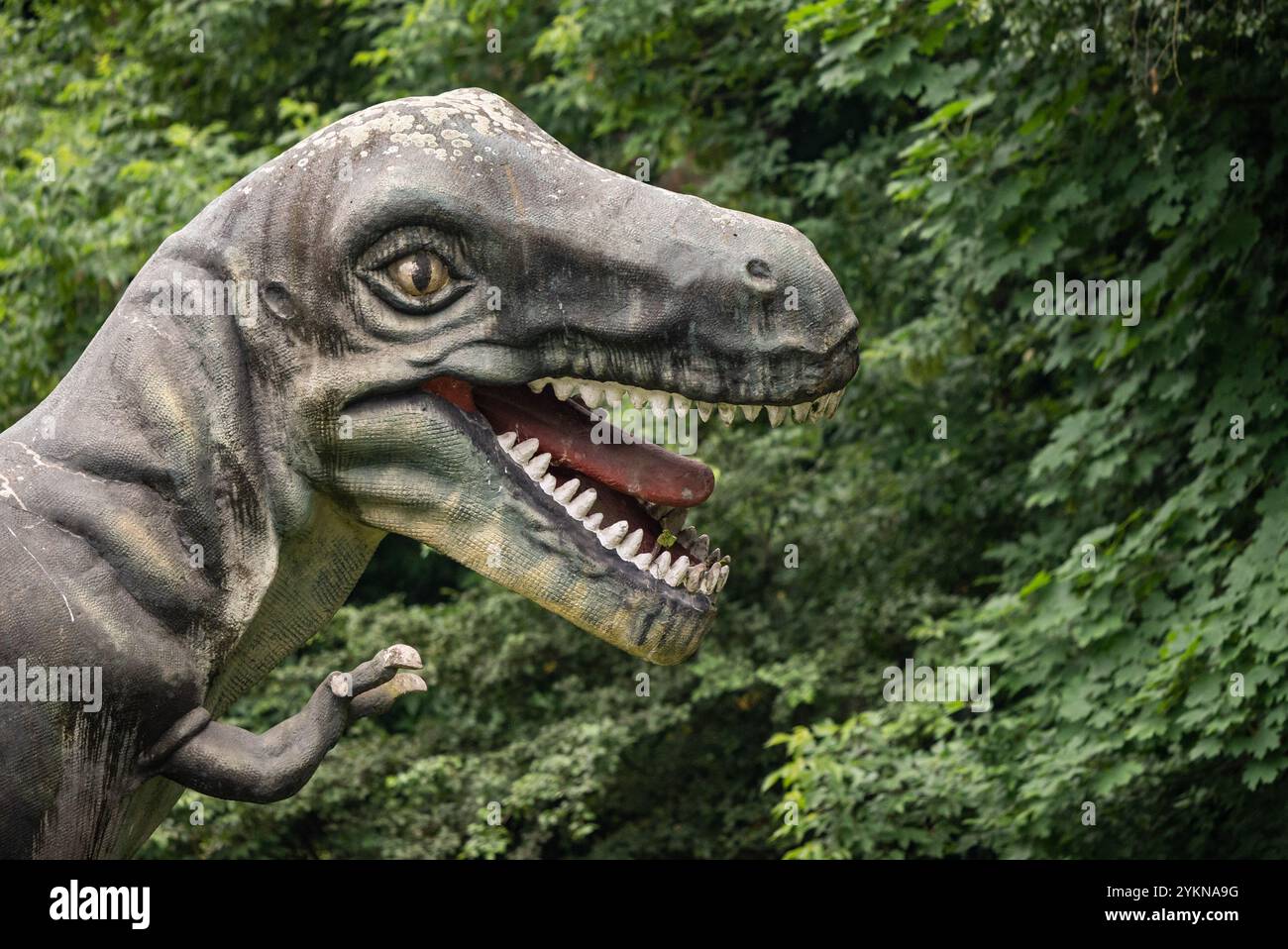A close up of a dinosaur sculpture in a park, showcasing its detailed ...