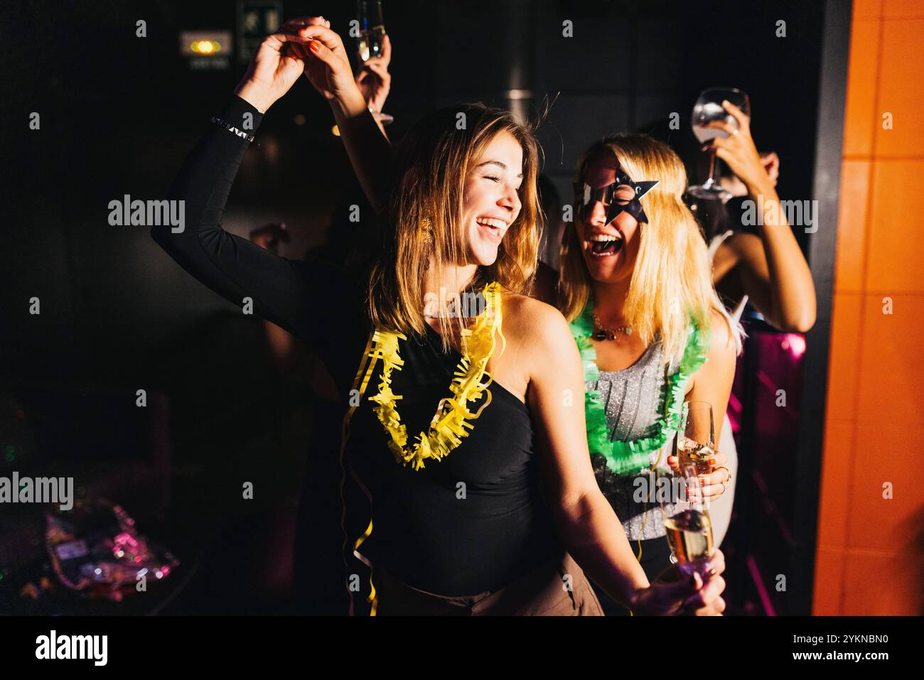Two cheerful friends enjoy a festive party, wearing colorful ...