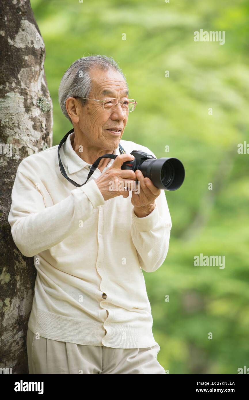 Senior man taking a photo with an SLR camera Stock Photo - Alamy