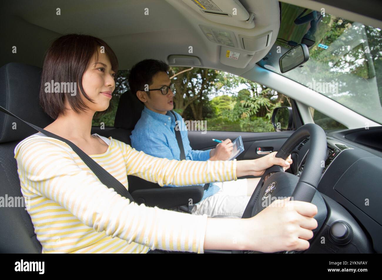 Young woman driving a car and driving school instructor Stock Photo - Alamy