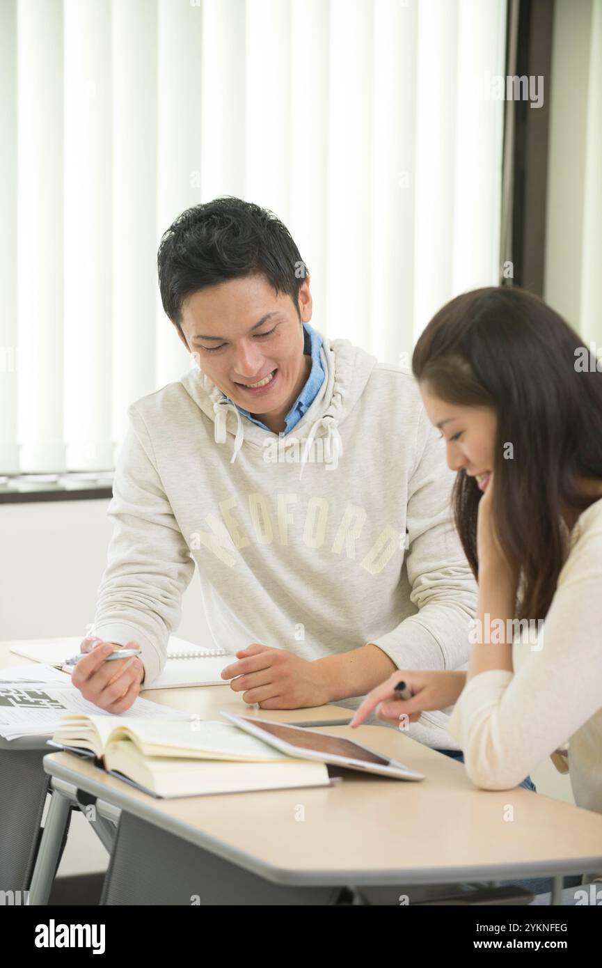A university student couple studying on their own in a lecture room ...