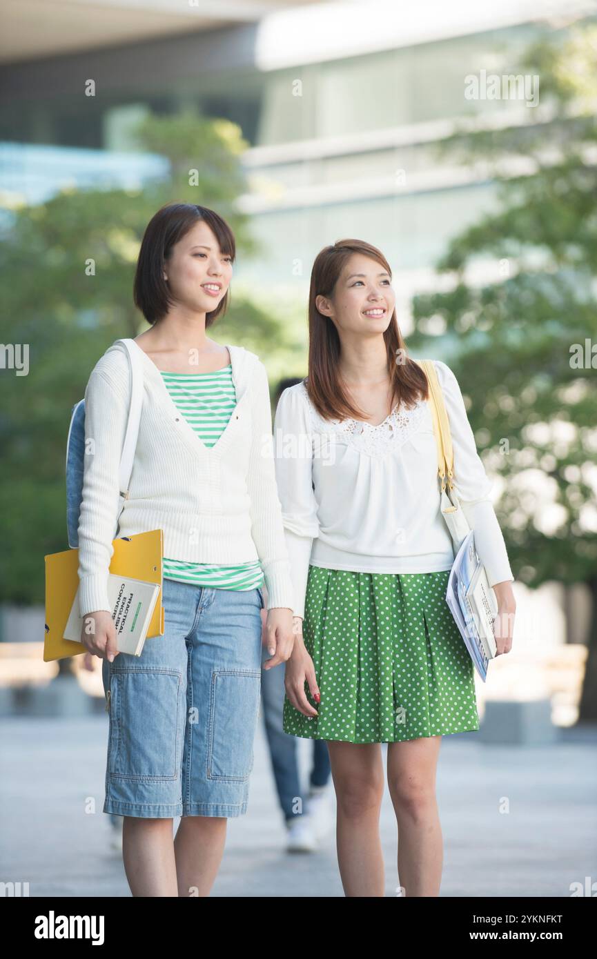 Two female university students walking on campus Stock Photo - Alamy