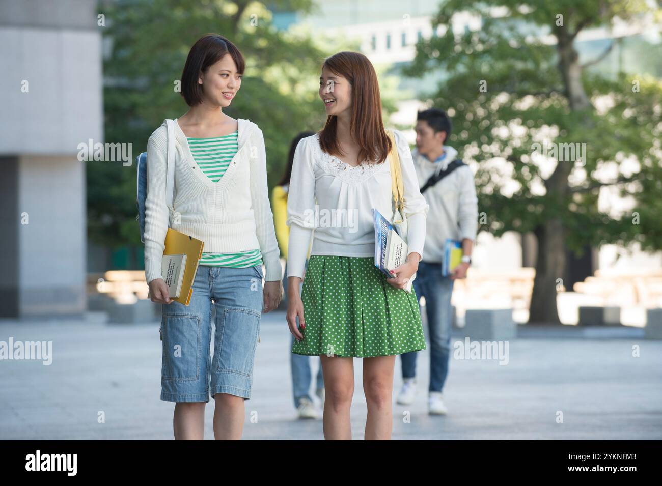 Two female university students walking on campus Stock Photo - Alamy