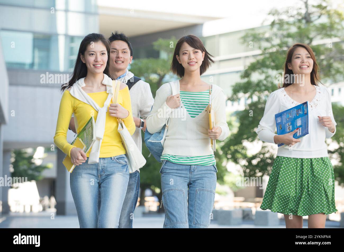Four university students, male and female, running on campus Stock ...