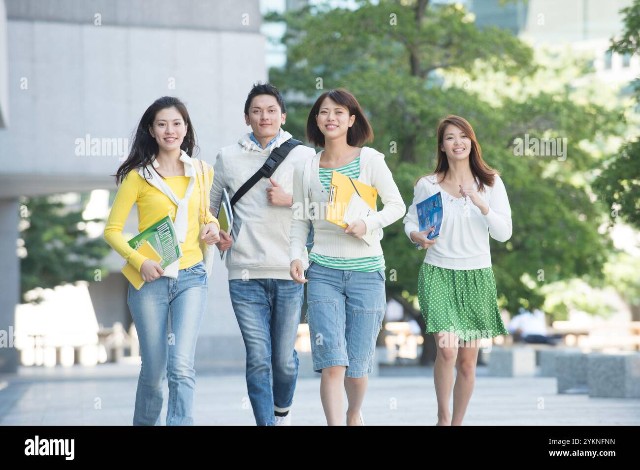 Four university students, male and female, running on campus Stock ...