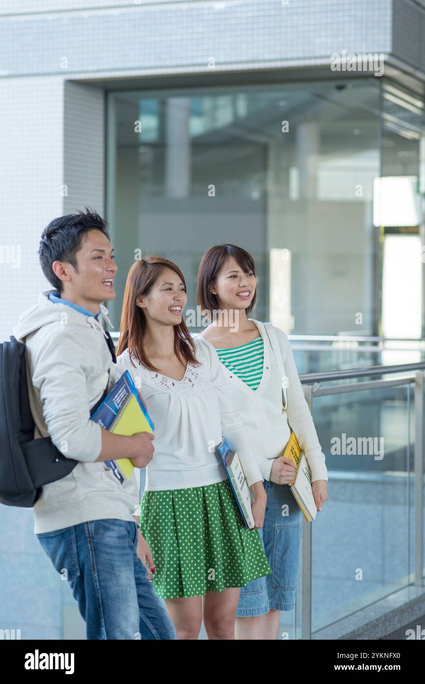 Three university students, male and female, in the school building ...