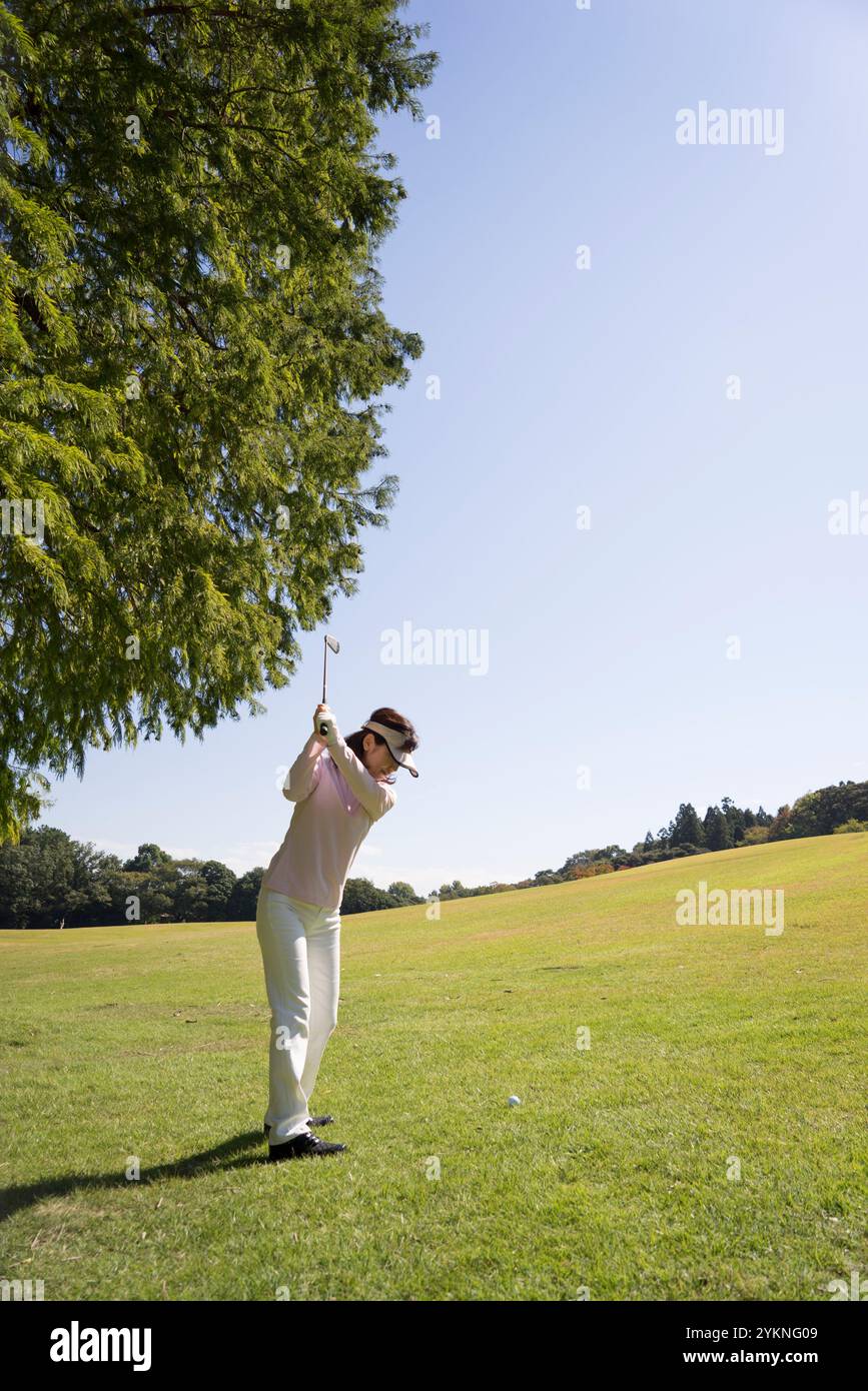 Middle-aged woman playing golf Stock Photo - Alamy