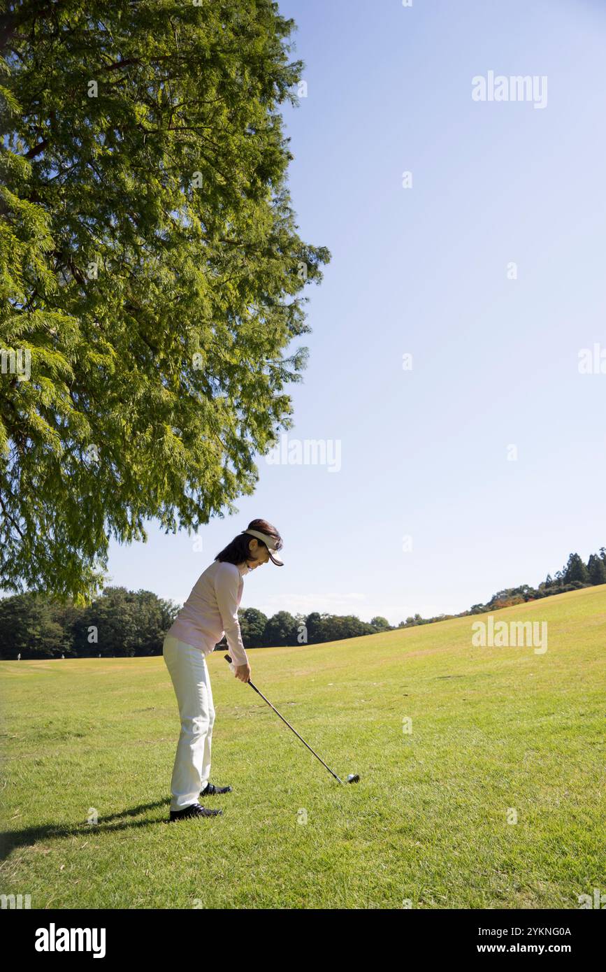 Middle-aged woman playing golf Stock Photo - Alamy
