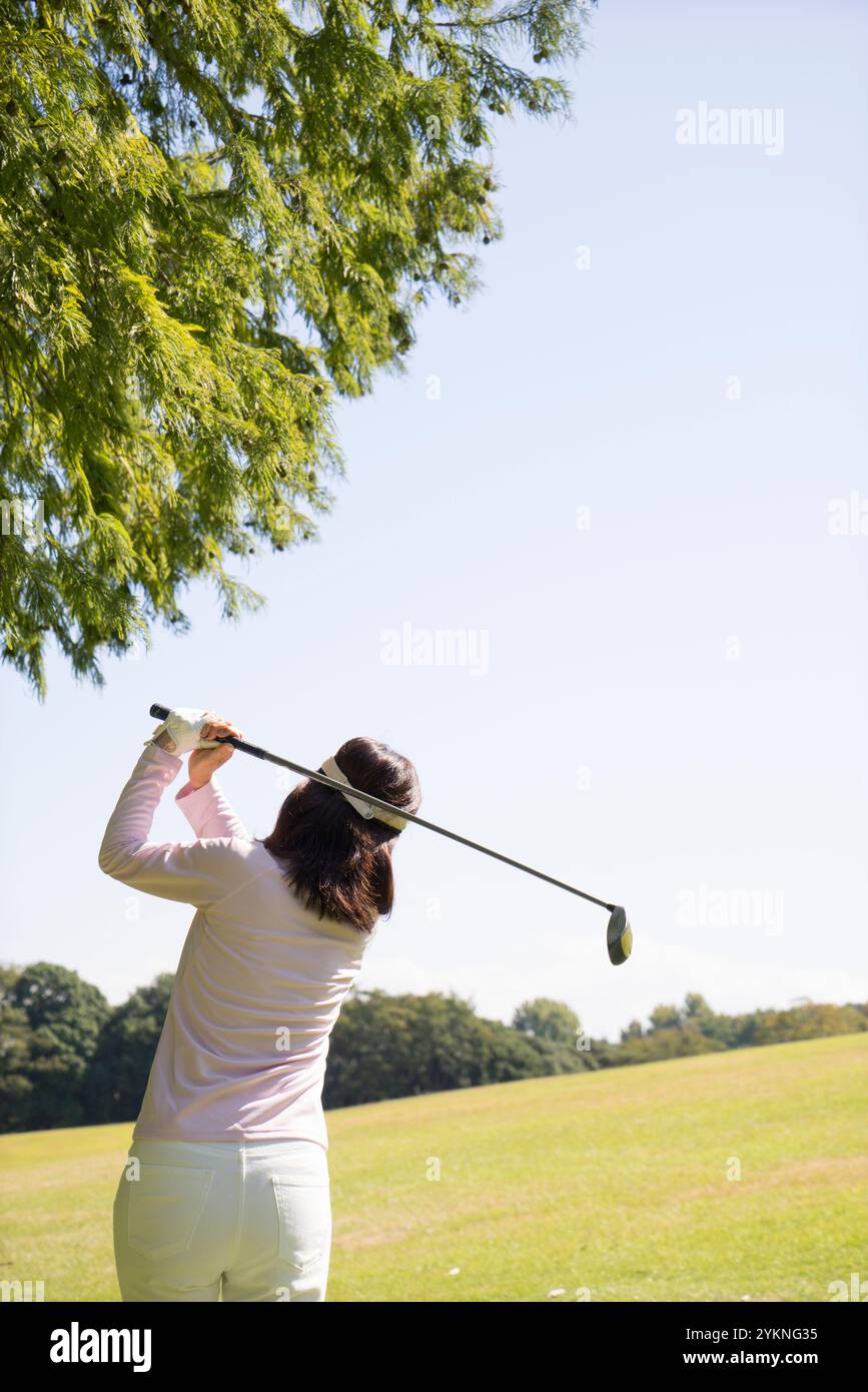 Middle-aged woman playing golf Stock Photo - Alamy