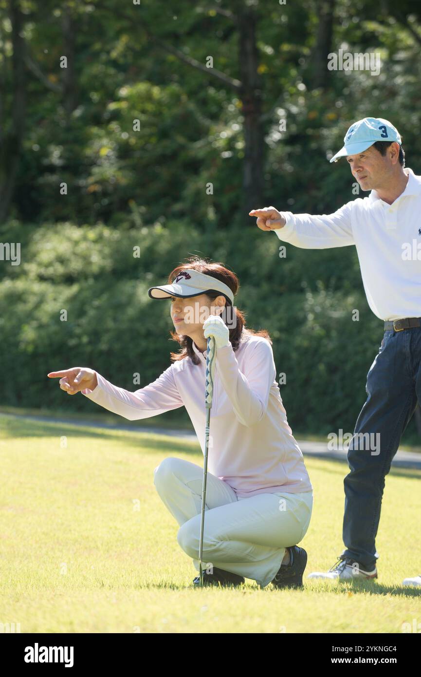 Middle-aged couple playing golf Stock Photo - Alamy