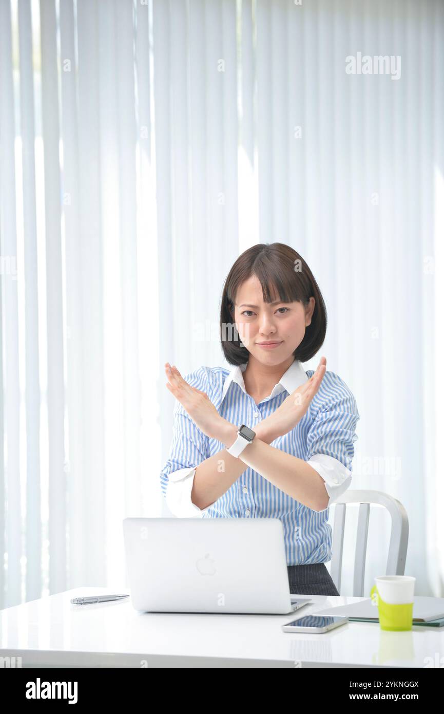 Office worker making an X with her hands Stock Photo - Alamy