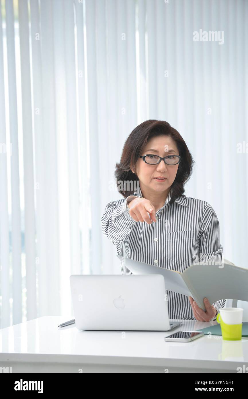 Businesswoman giving directions with a file Stock Photo - Alamy