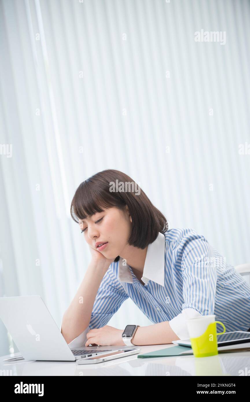 Office worker at desk sleeping with cheekbones Stock Photo - Alamy