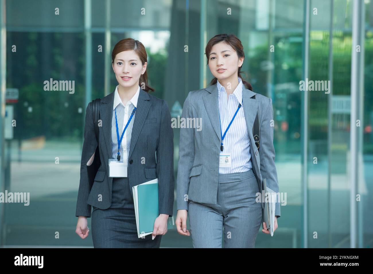 Two office workers walking through office building Stock Photo - Alamy