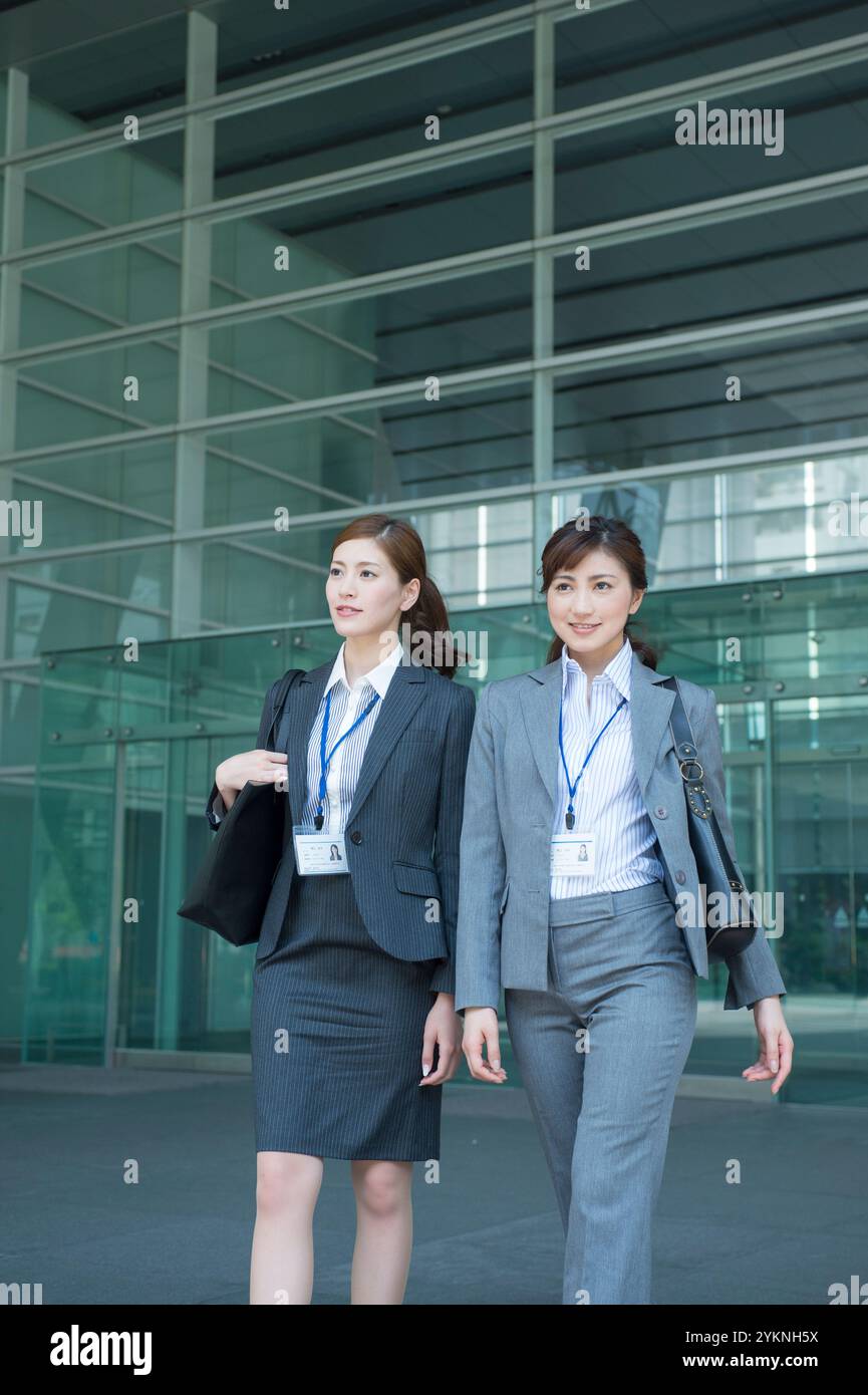 Two office workers walking through office building Stock Photo - Alamy