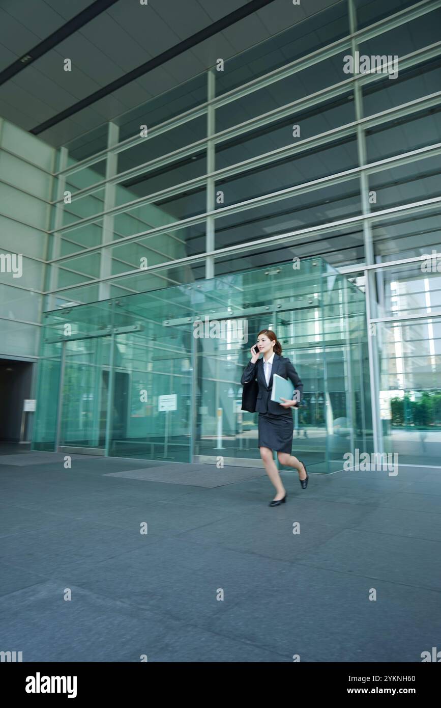 Office worker running through office building while on phone Stock ...