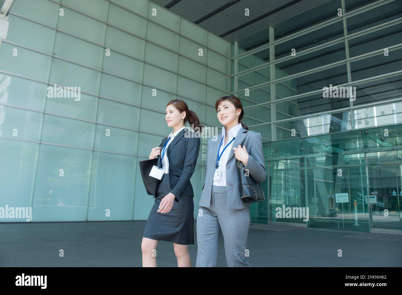 Two office workers walking through office building Stock Photo - Alamy