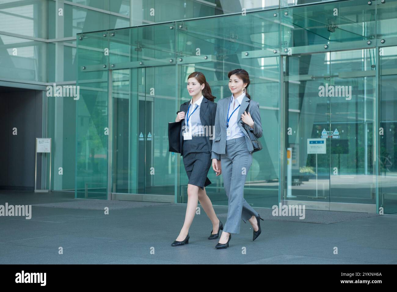 Two office workers walking through office building Stock Photo - Alamy