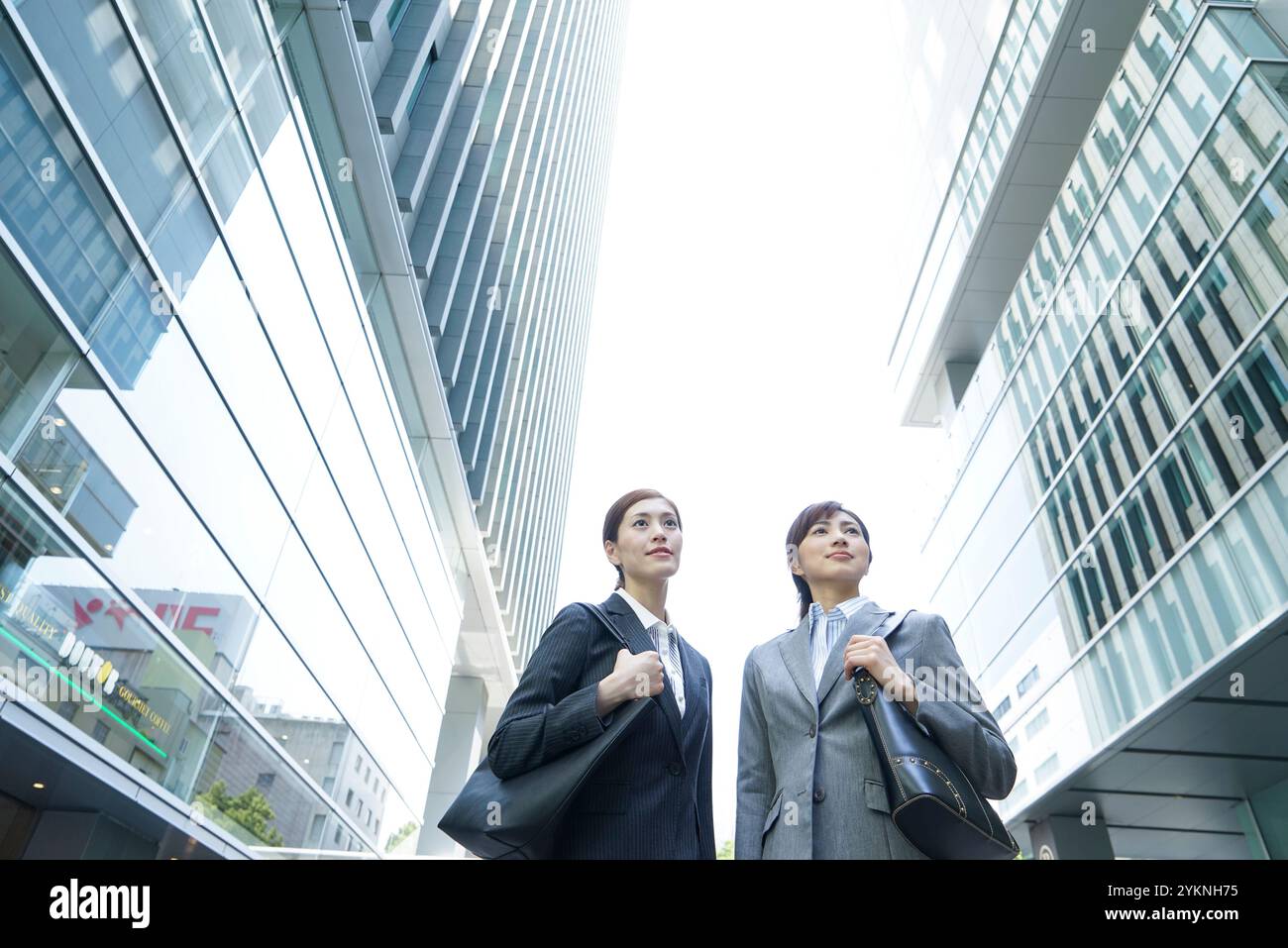 Two office workers standing in office building Stock Photo - Alamy