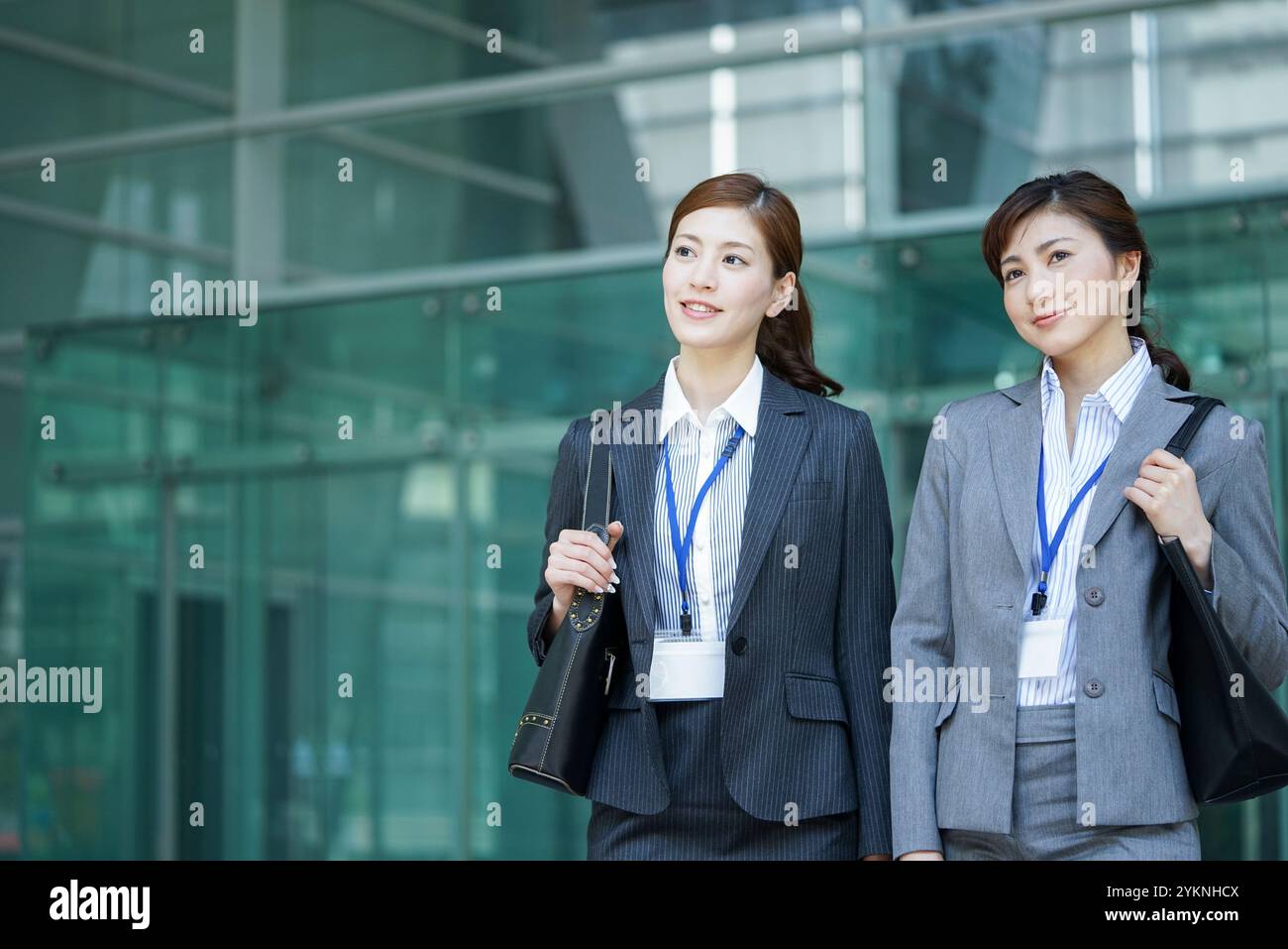 Two office workers walking through office building Stock Photo - Alamy